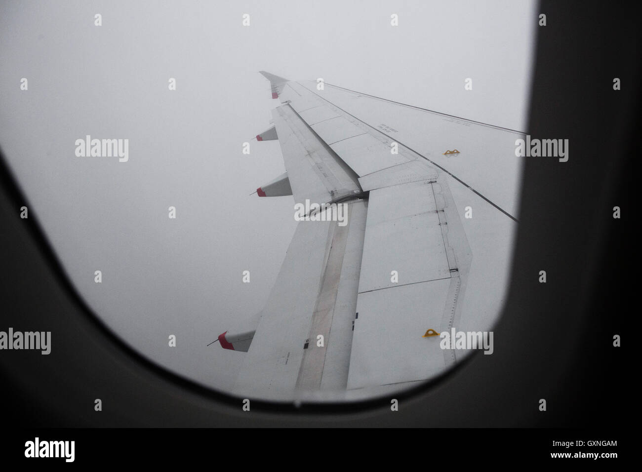 View through an aeroplane window at the wing as it flies through bad ...