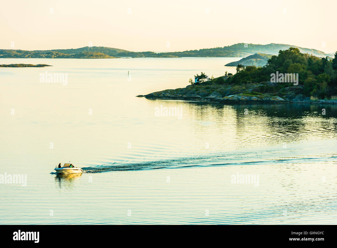 Small motorboat moving slowly through windless sea in the Swedish west ...