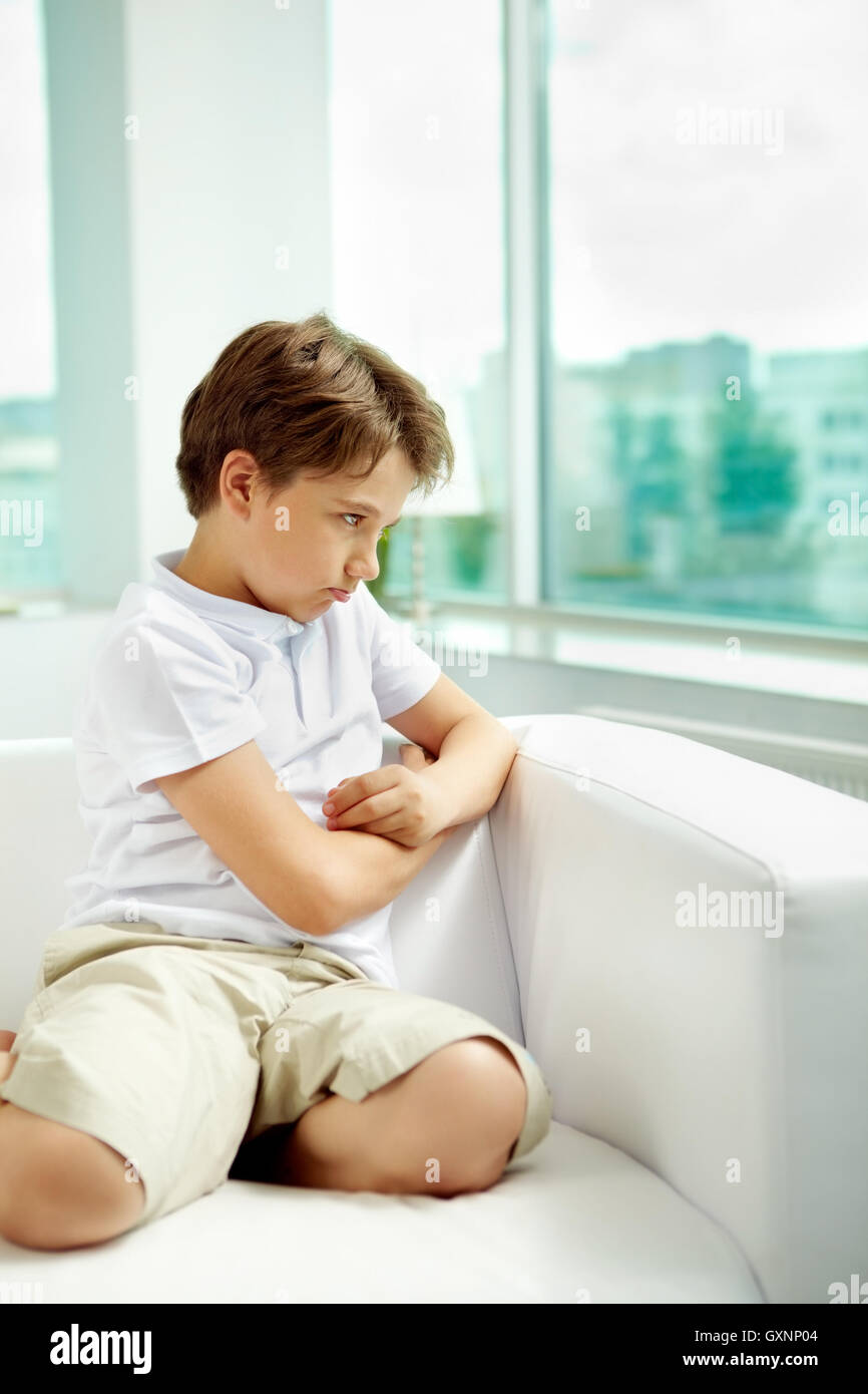 Sulky boy on sofa Stock Photo - Alamy