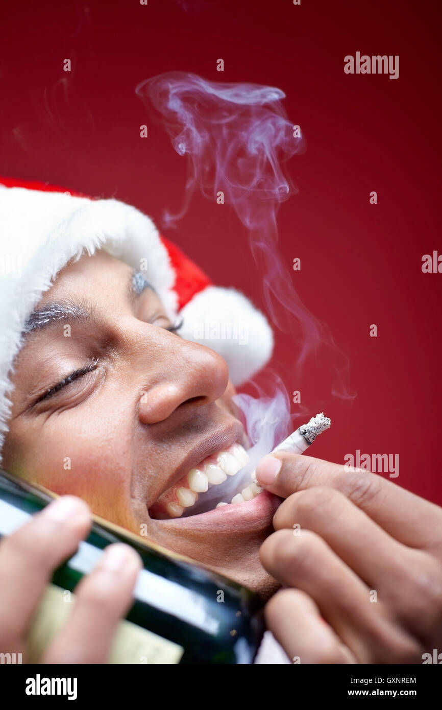 Smiling young Santa man smoking Stock Photo - Alamy