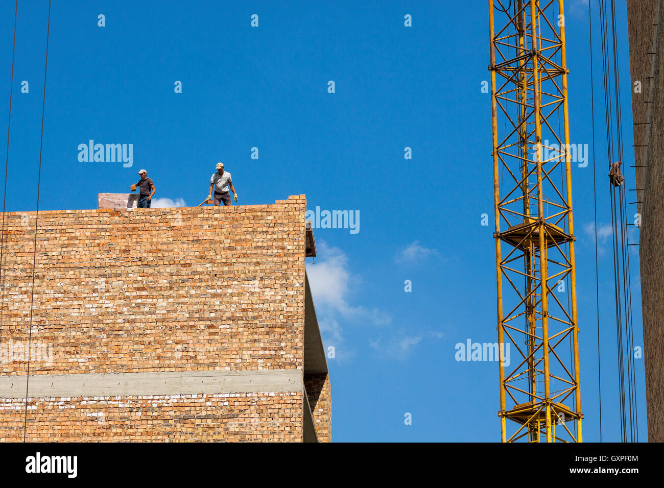 Building brick block wall on construction. Construction mason worker ...