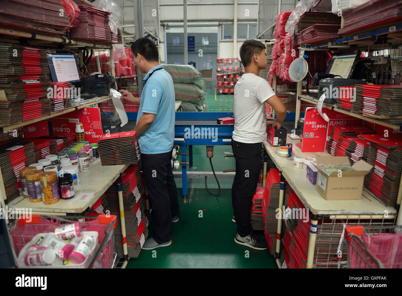 Workers wrap parcels of goods shopped from overseas through Jumei ...