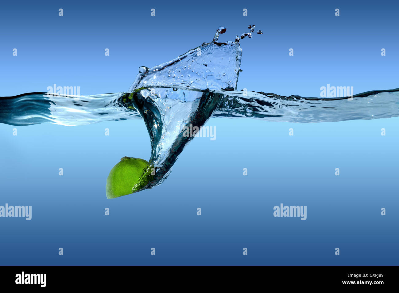 fruits lime in water on a blue background Stock Photo - Alamy