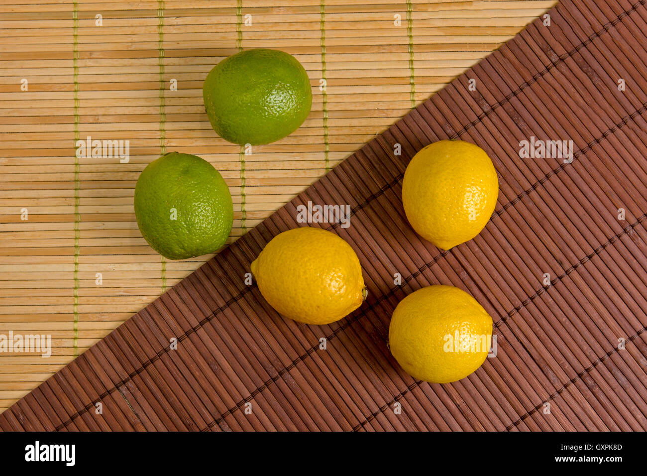 lime and a lemon lie on mats made of bamboo Stock Photo - Alamy