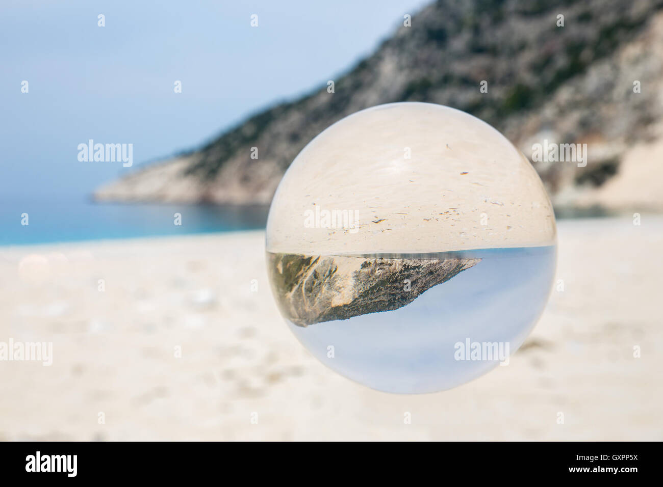 Crystal ball on sandy greek beach with sea and mountain Stock Photo - Alamy