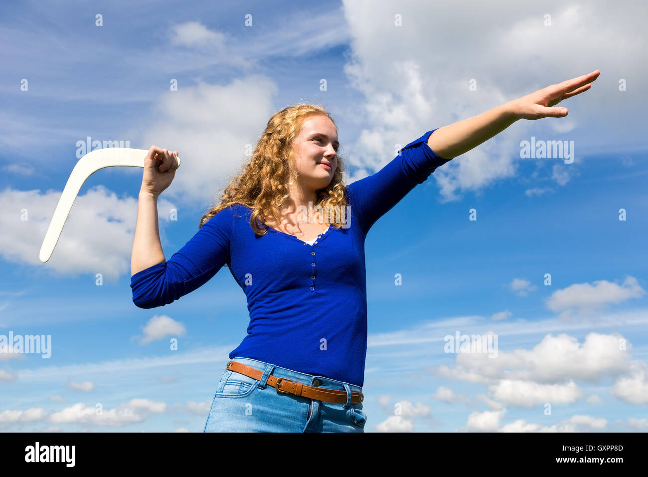 Young dutch woman throwing boomerang with blue sky Stock Photo - Alamy