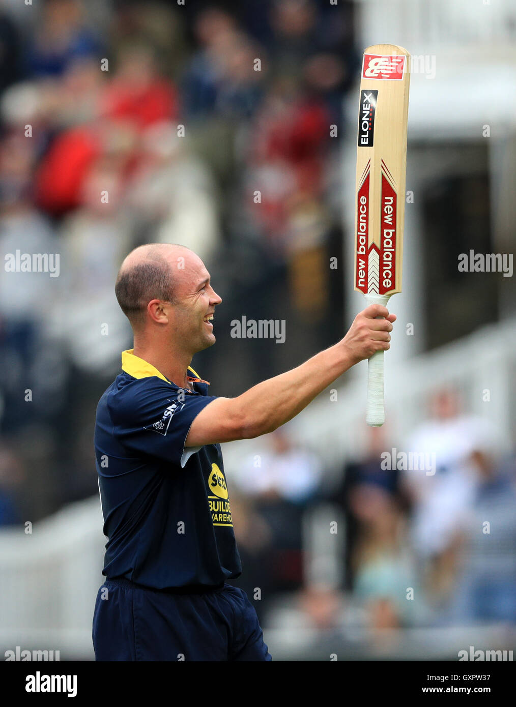 Warwickshire's Jonathan Trott smiles as he raises his bat to the crowd ...