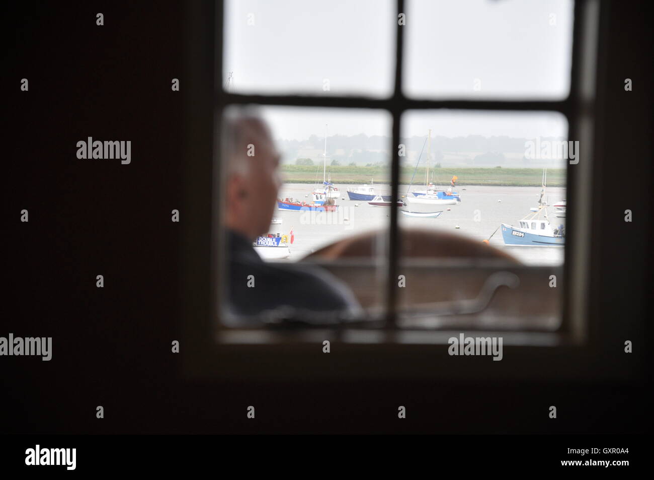 Man and boats through window Stock Photo - Alamy
