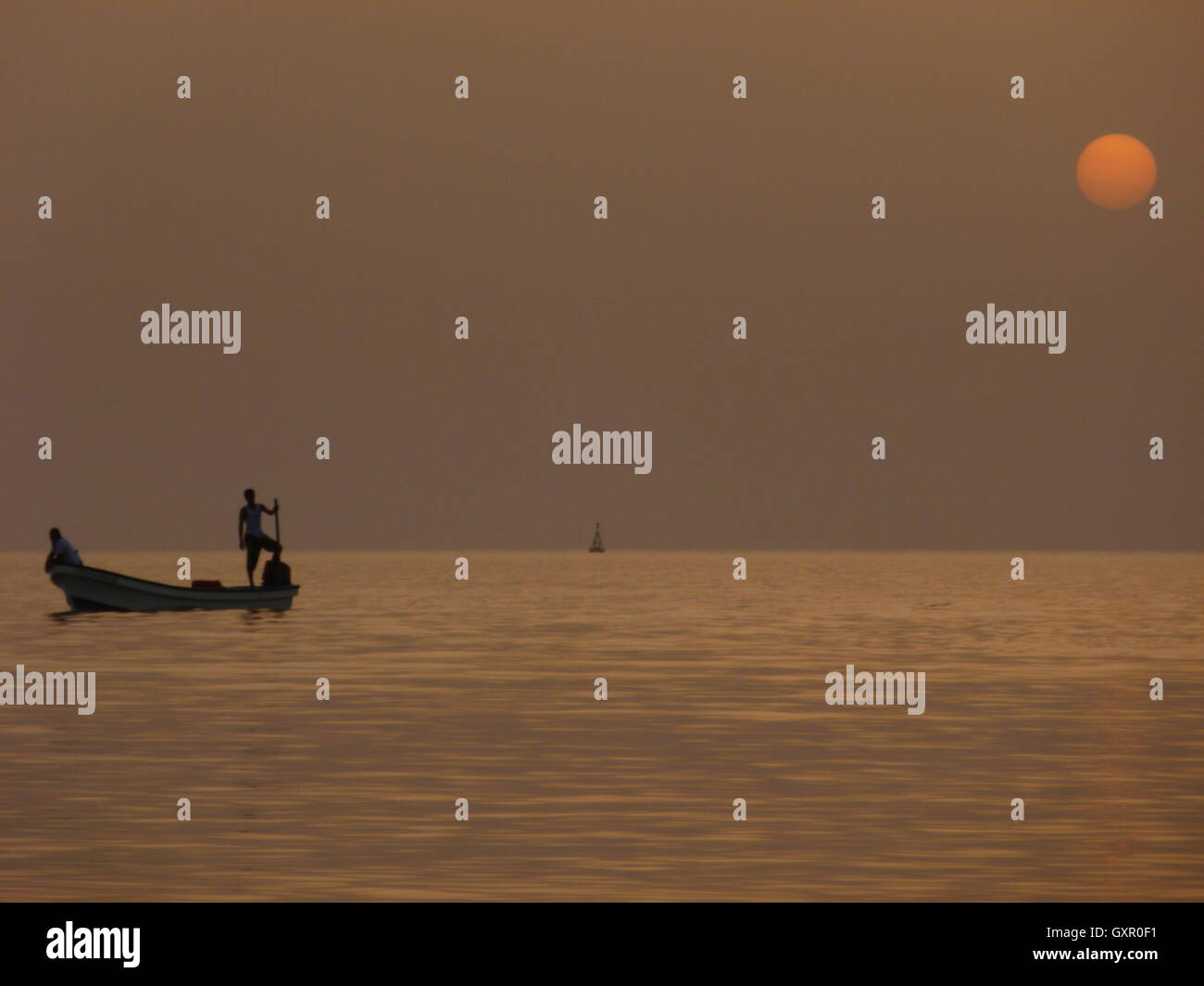 Man standing in boat at sunset Stock Photo - Alamy
