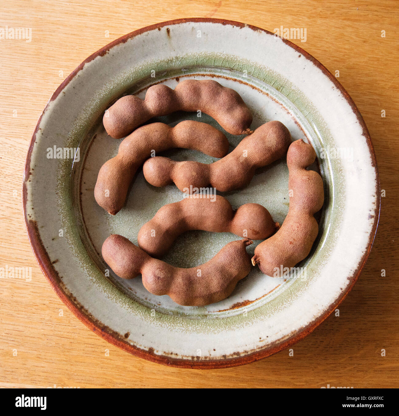 A plate of tamarind ( Tamarindus indica ) pods on a table Stock Photo ...