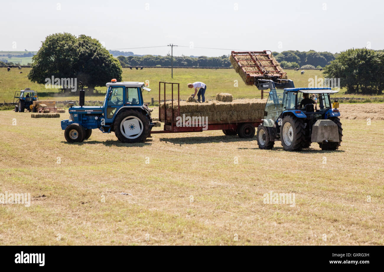 Loading hay bales onto a tractor trailer on a farm in the Derbyshire ...
