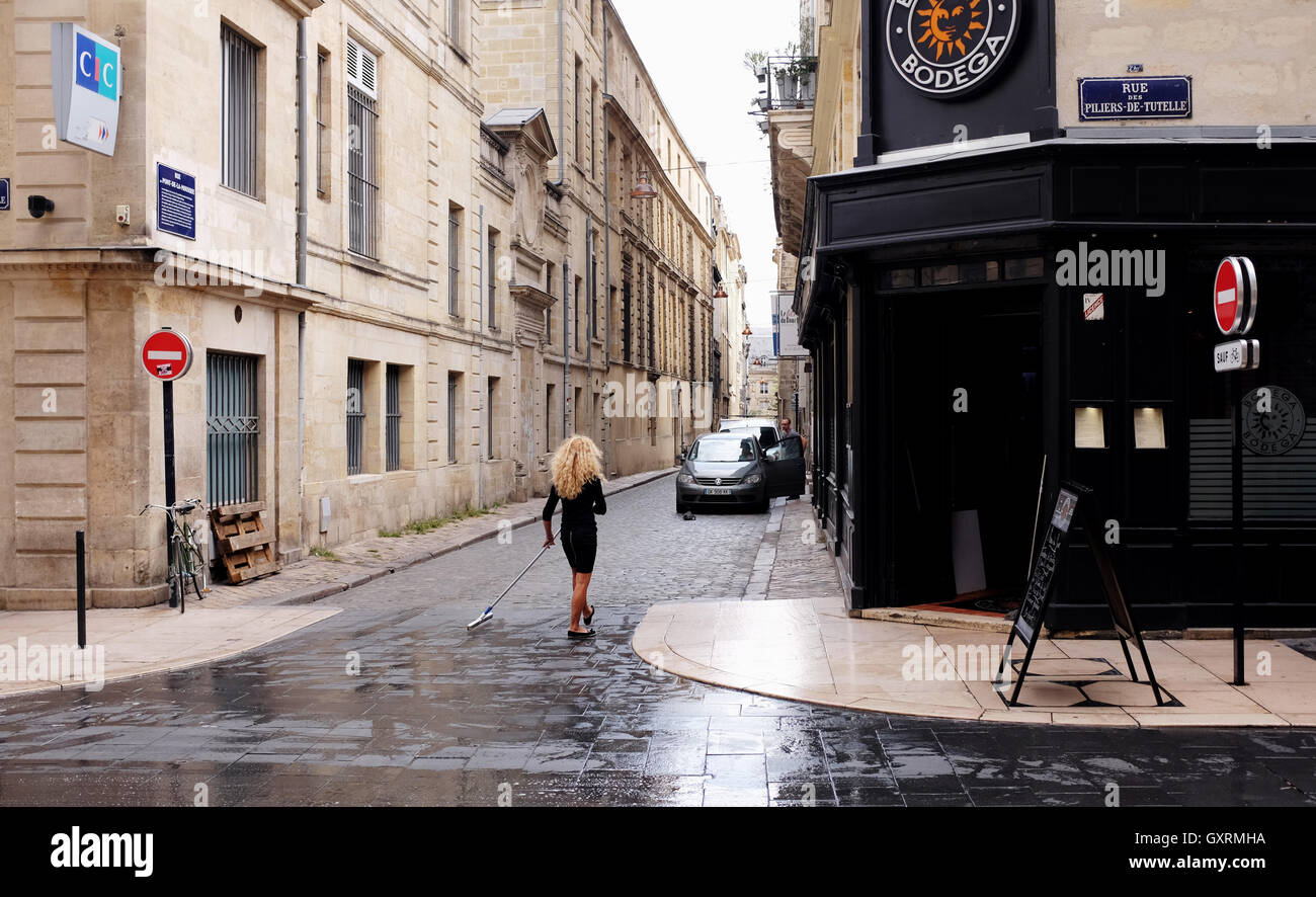 Woman cleaning street outside her restaurant in Bordeaux Stock Photo ...