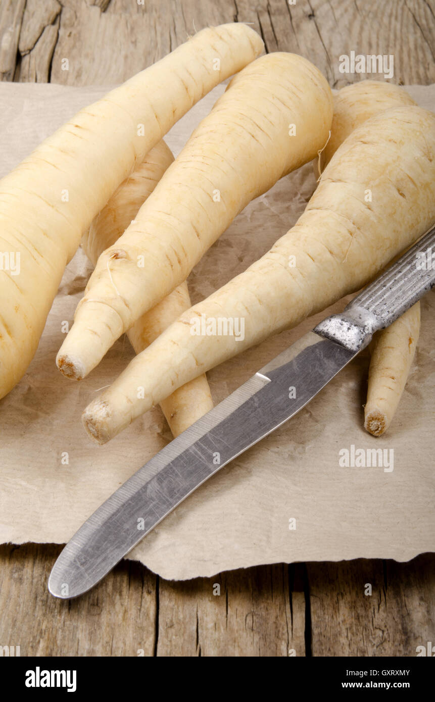 parsnip lie with a knife on brown paper Stock Photo - Alamy