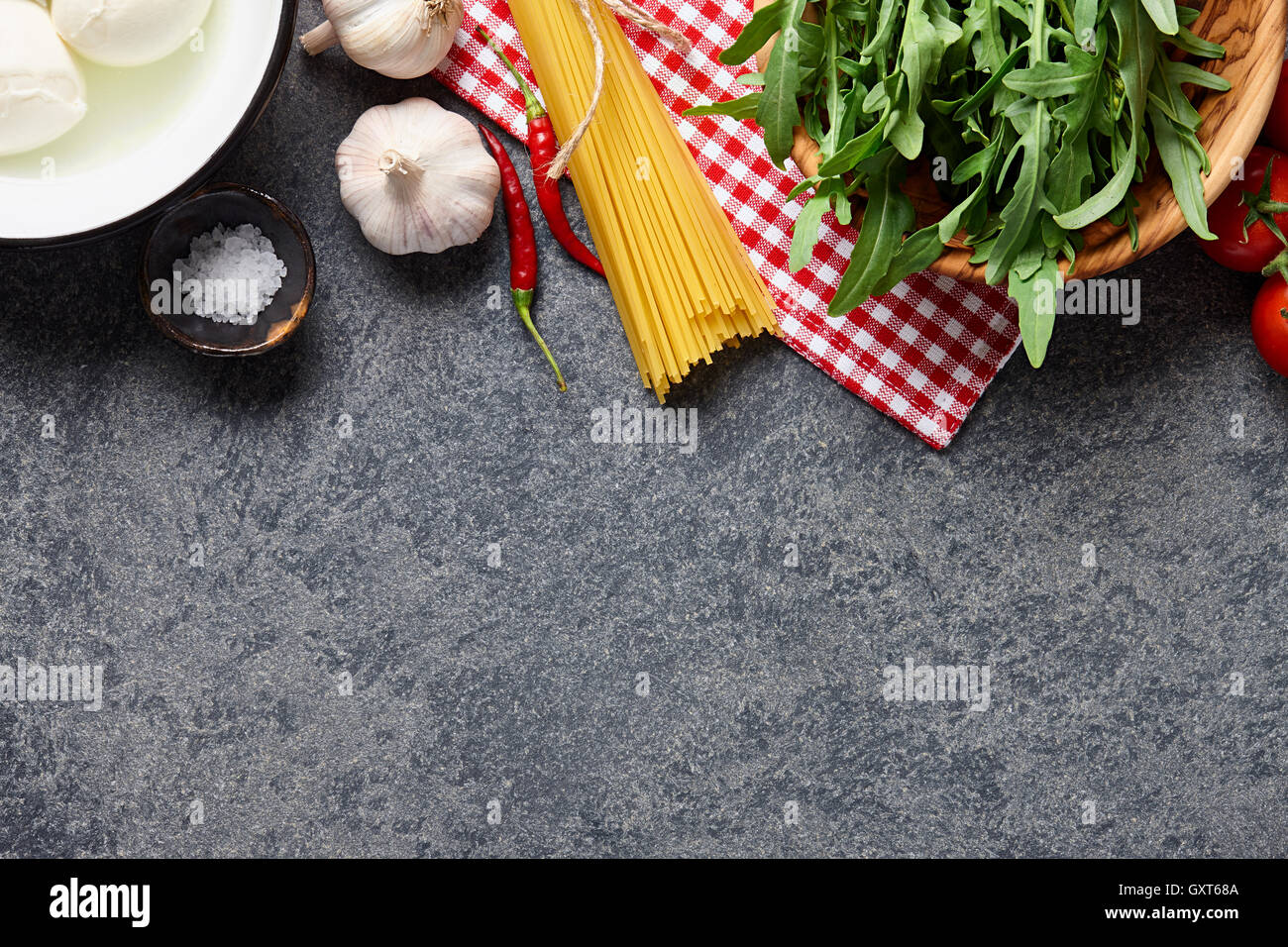 Italian food ingredients background with raw spaghetti, rocket salad ...