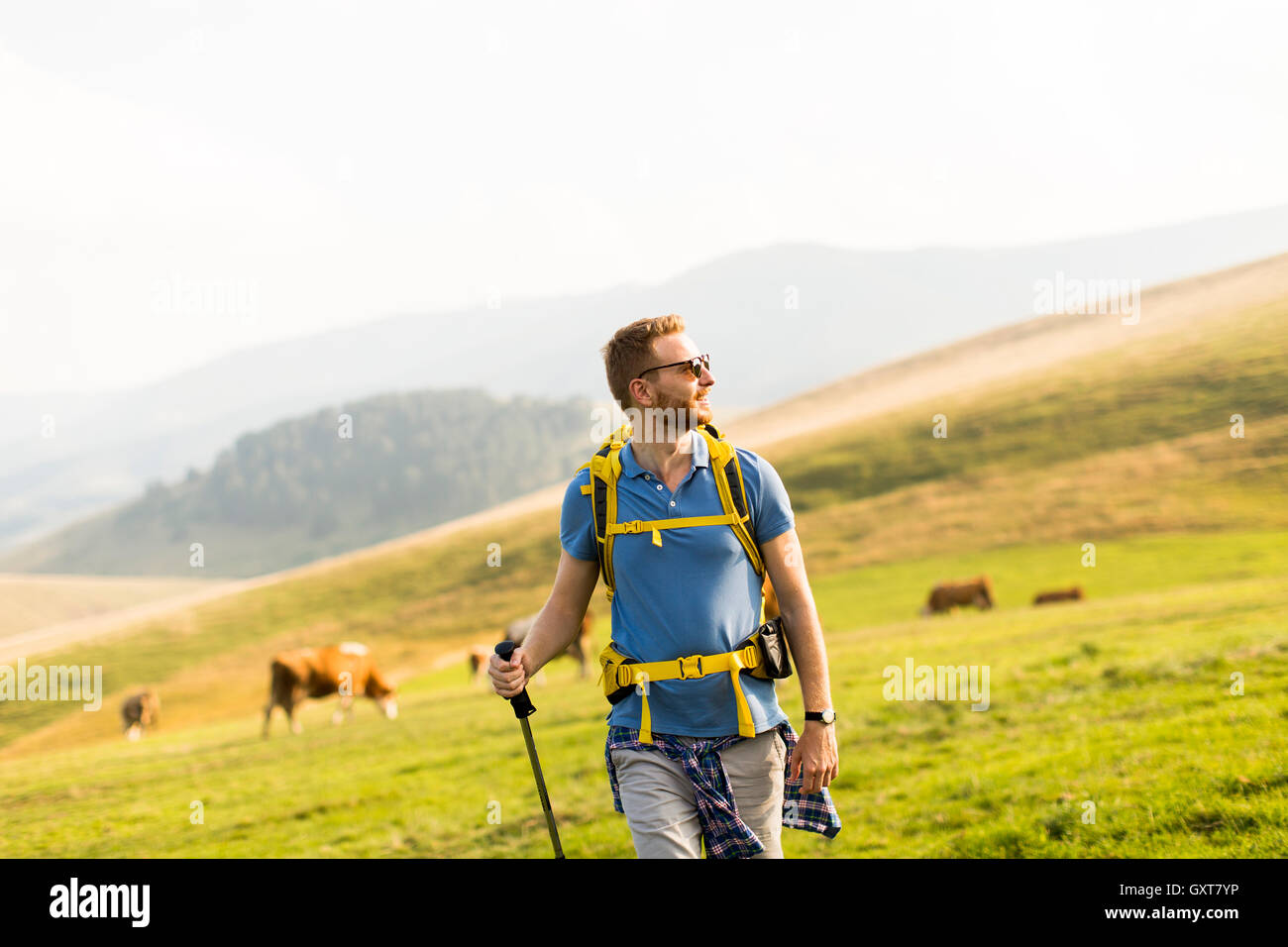 View of happy young man hiking in countryside Stock Photo - Alamy
