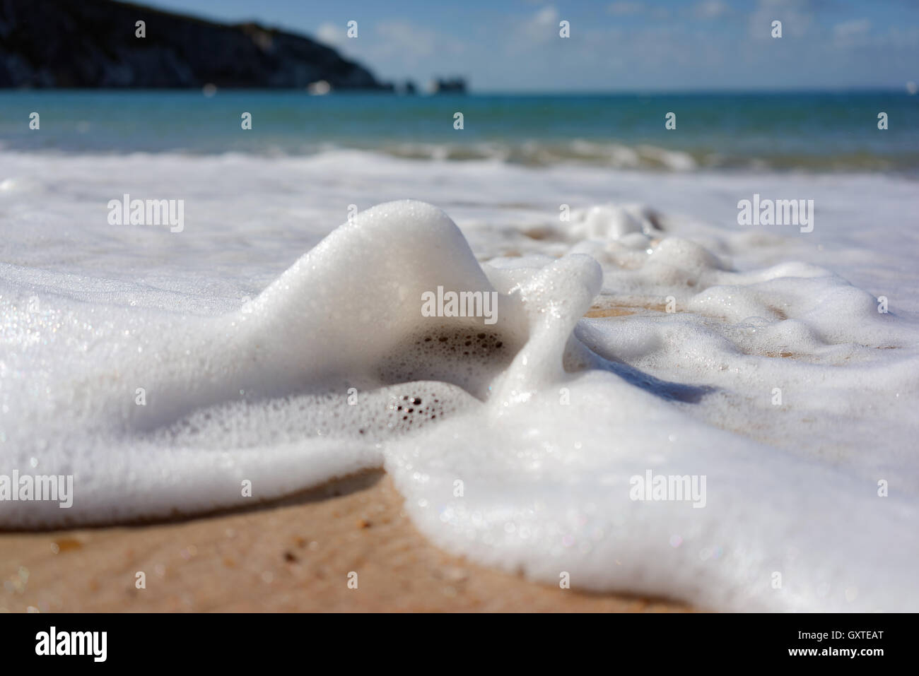 Frothy water on a beach Stock Photo - Alamy