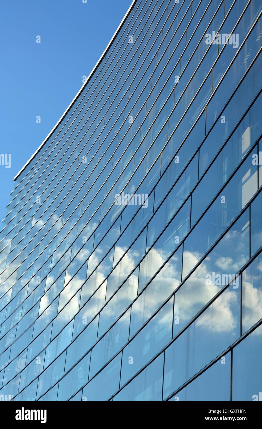 Detail of glass facade of modern office building with reflection of ...