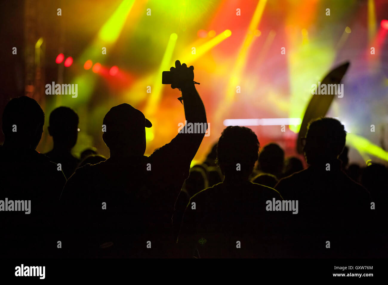 Cheering crowd in front of bright colorful stage lights Stock Photo - Alamy