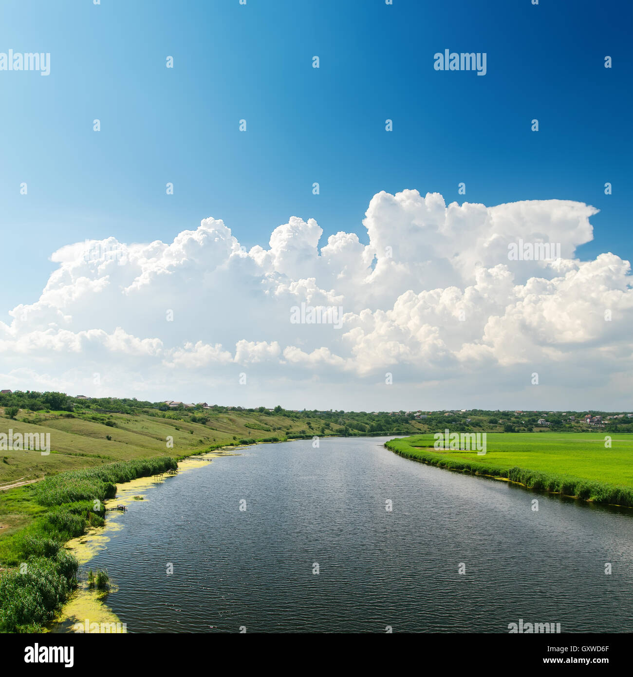 cloudy sky over river with green sides Stock Photo - Alamy