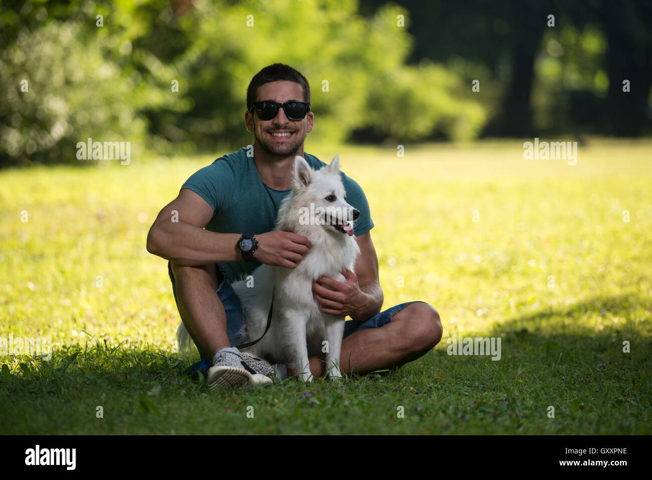 Man And German Spitz Sitting In The Park - Together Enjoying The View ...