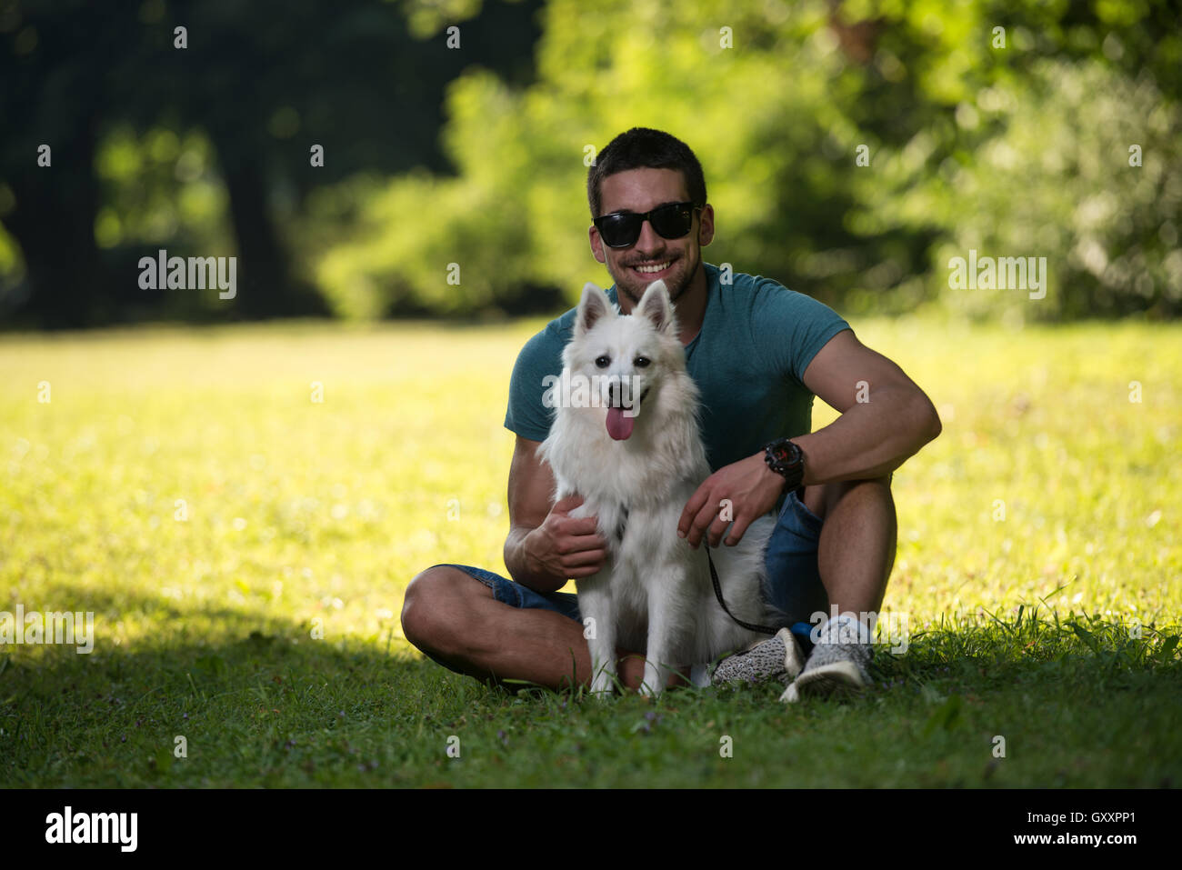 Man And German Spitz Sitting In The Park - Together Enjoying The View ...