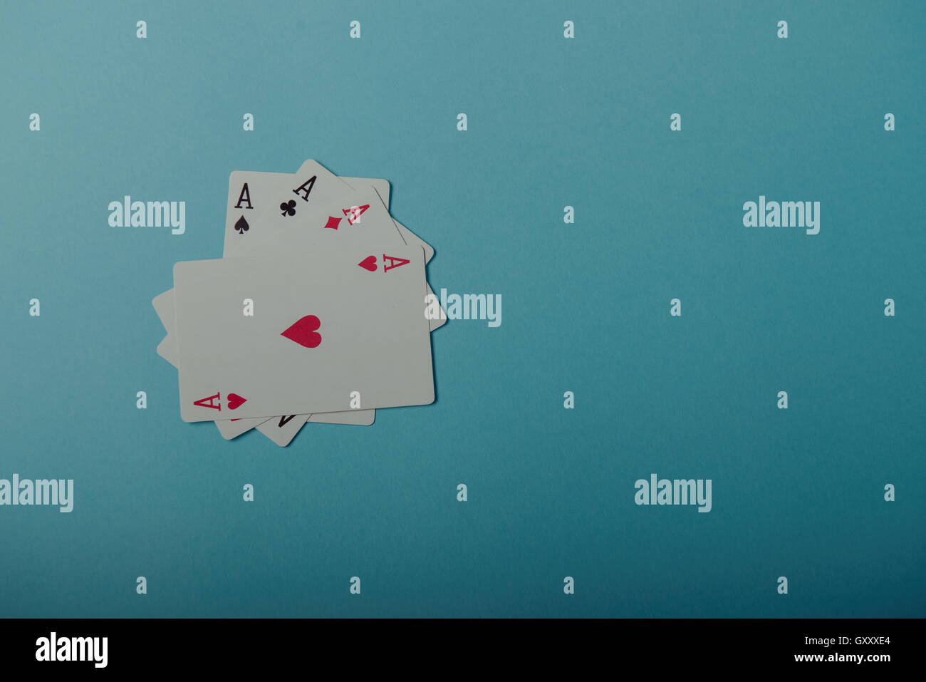 A winning poker hand of four aces playing cards on blue background ...