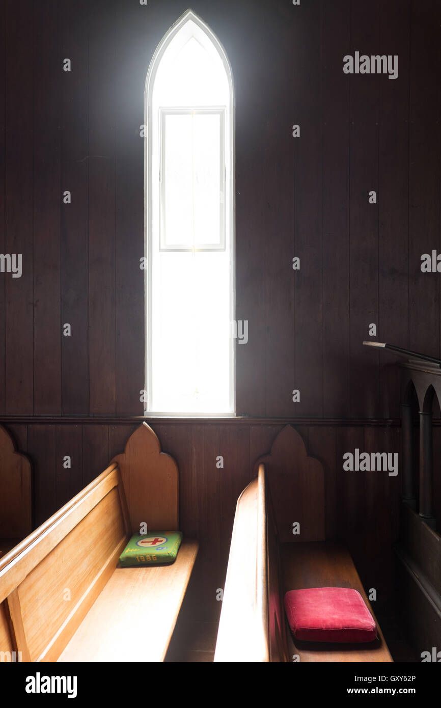 Light shining through a church window onto wooden pews. Photographed in ...