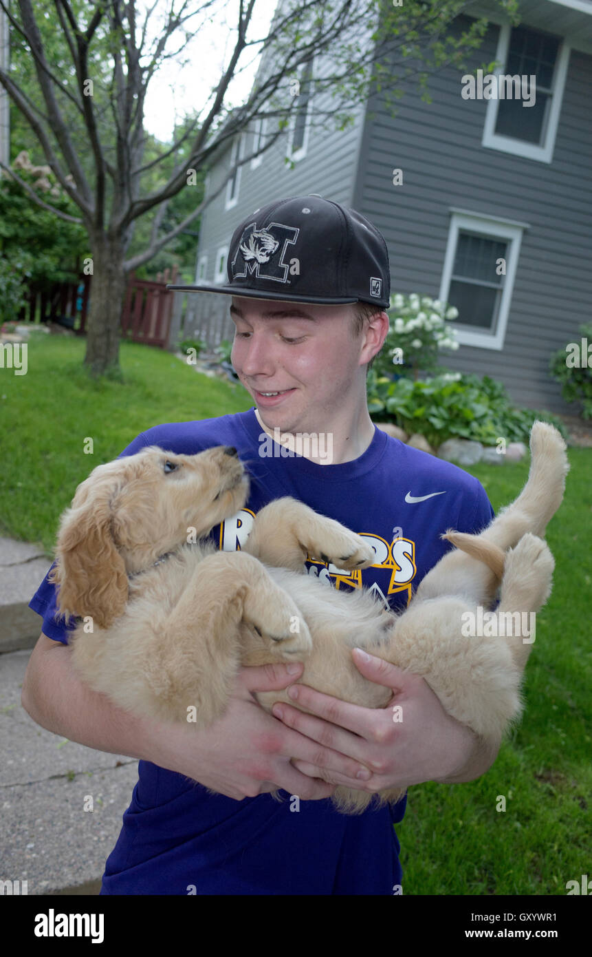My teenage grandson holding Odin, his new Goldendoodle puppy in front ...