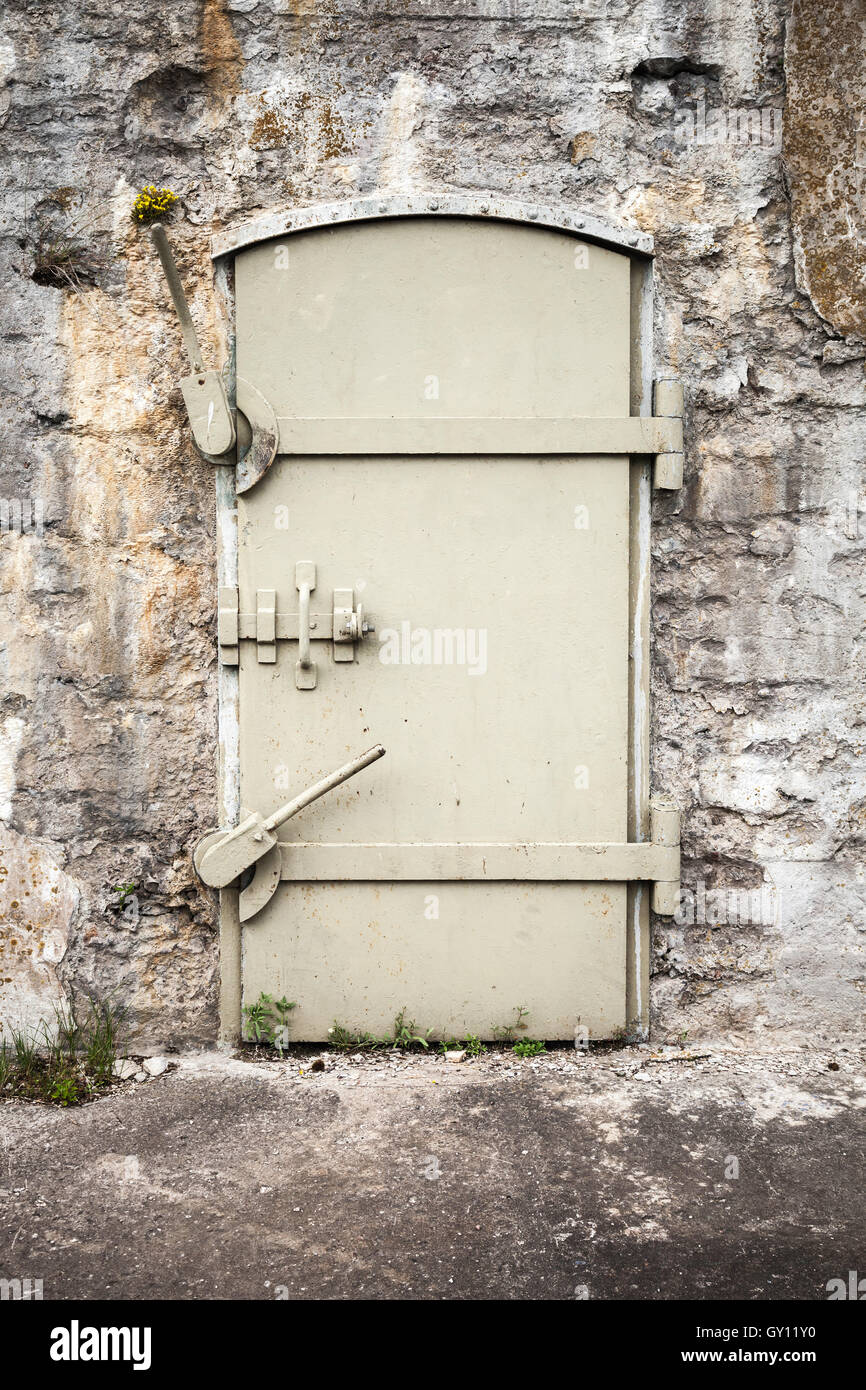 Closed massive metal door in old fortification wall, background texture ...