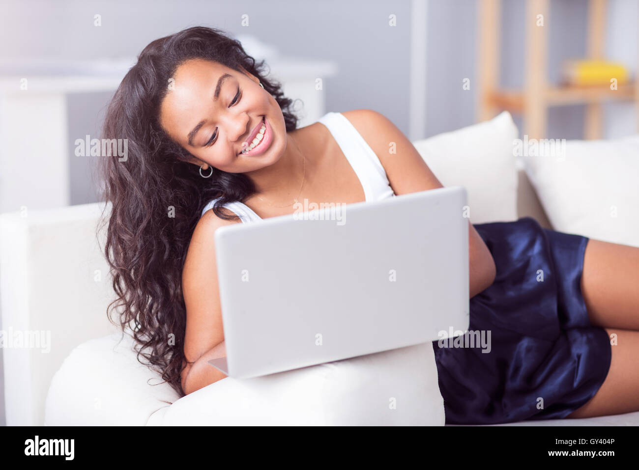 Joyful beautiful woman resting on the couch Stock Photo - Alamy