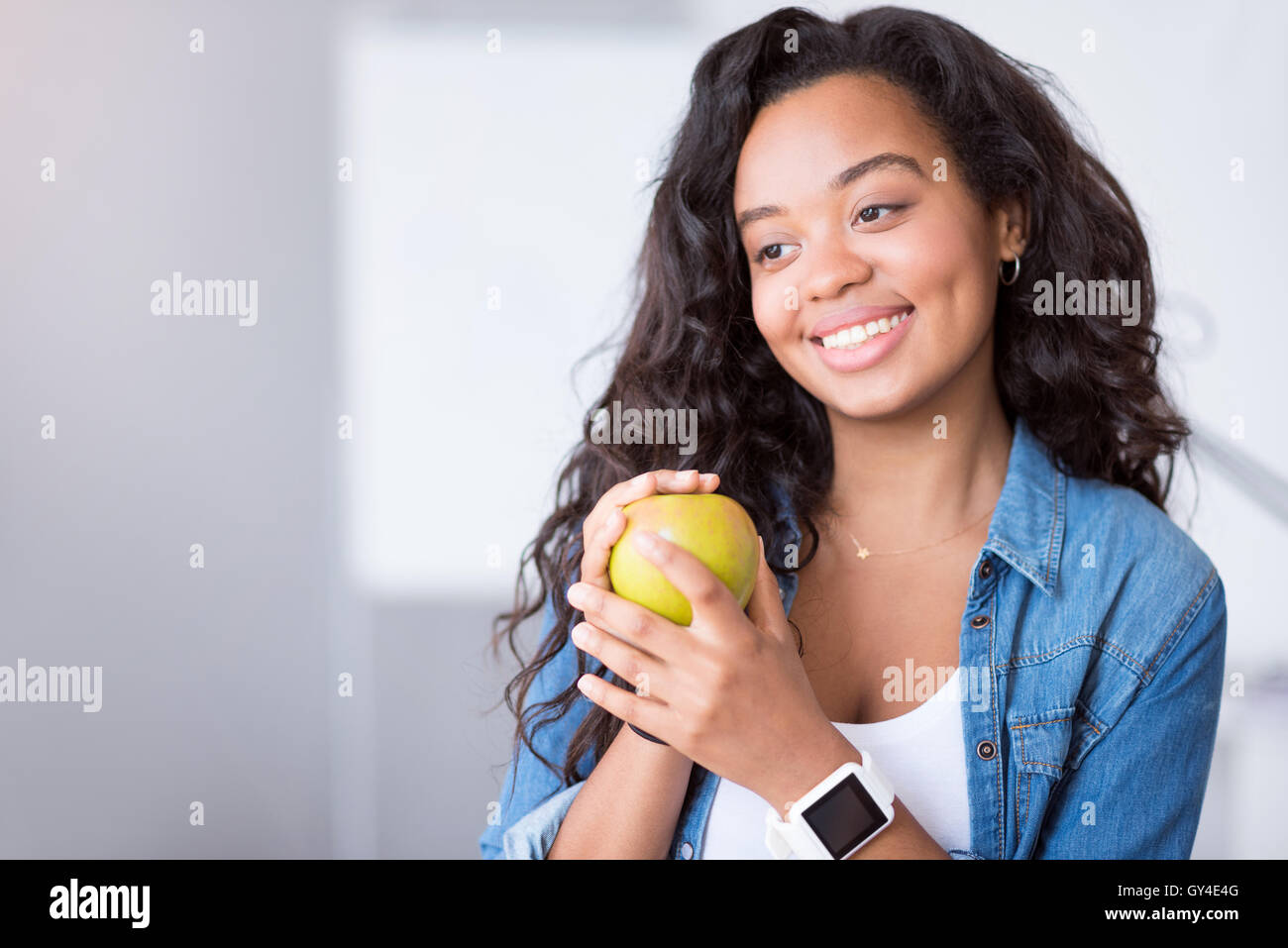Positive young woman holding an apple Stock Photo - Alamy