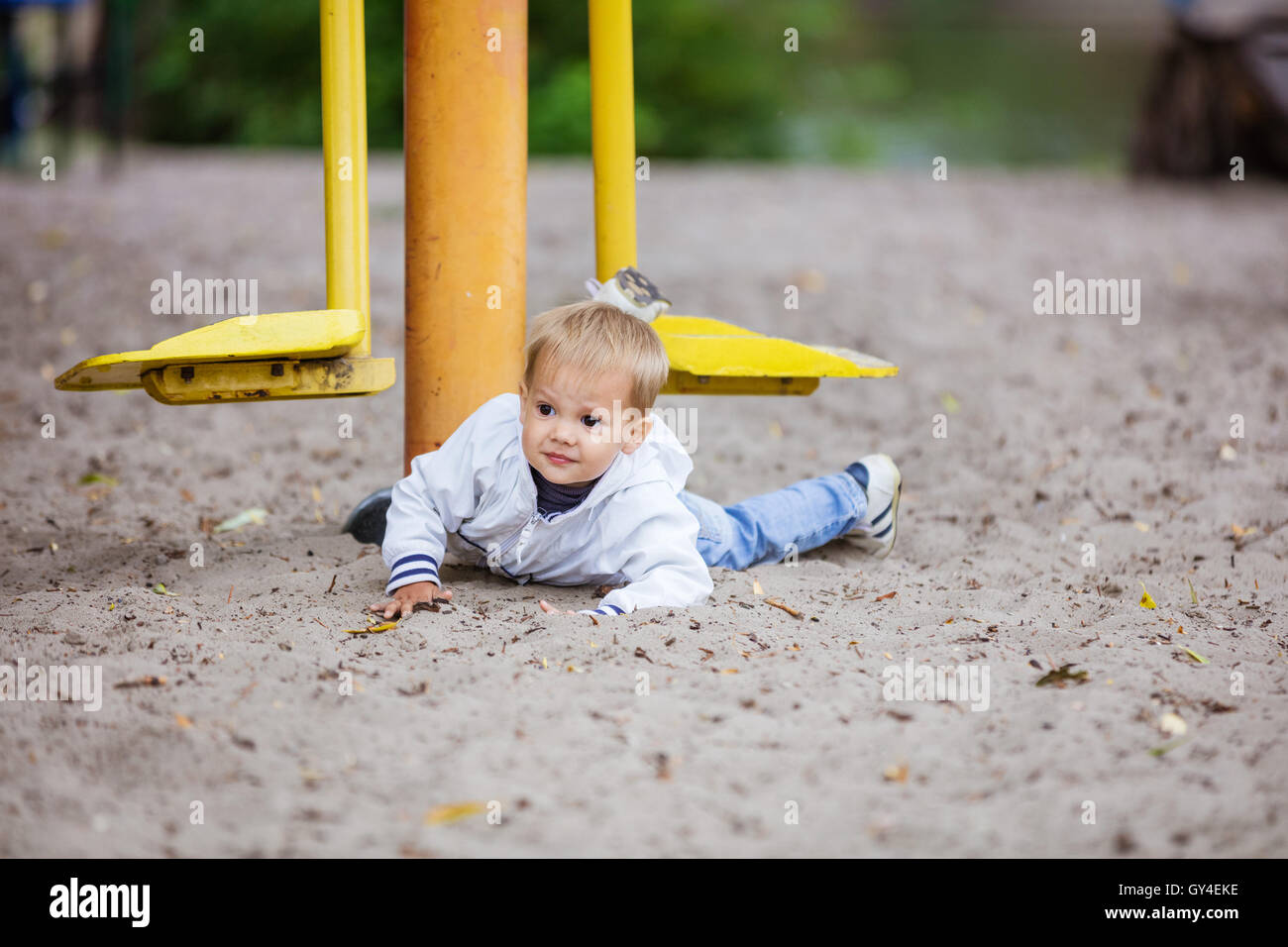 Toddler boy falling from outdoor exercise machine Stock Photo - Alamy