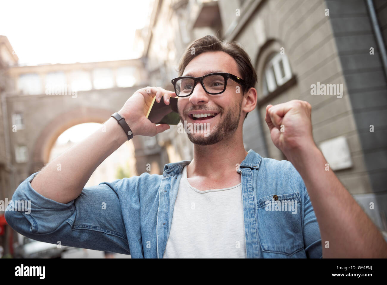 Delighted young man making a phone call Stock Photo - Alamy