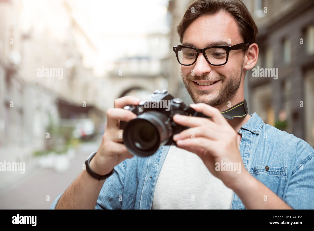 Professional young photographer holding his camera Stock Photo - Alamy