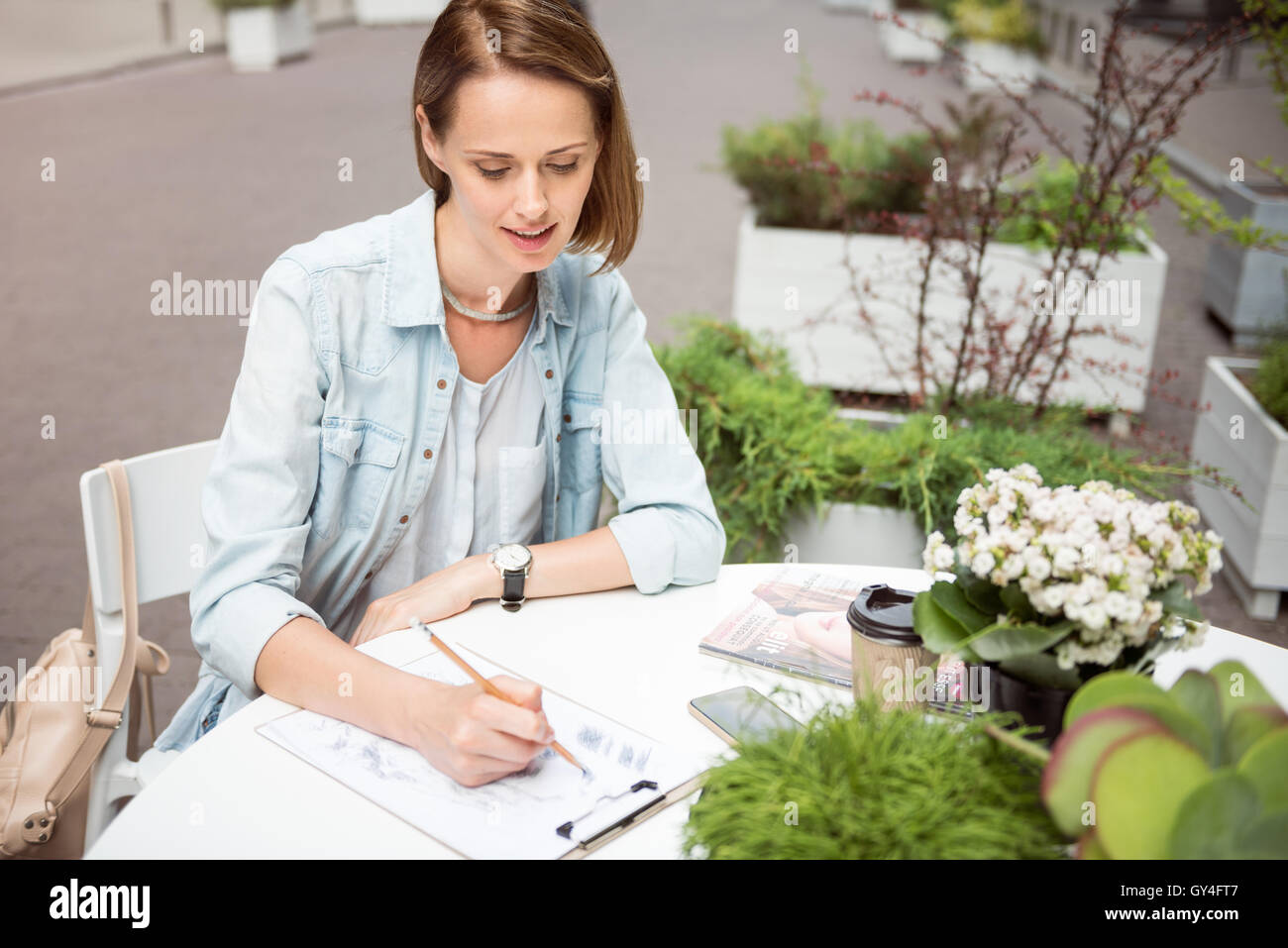 Beautiful young lady drawing a picture Stock Photo - Alamy