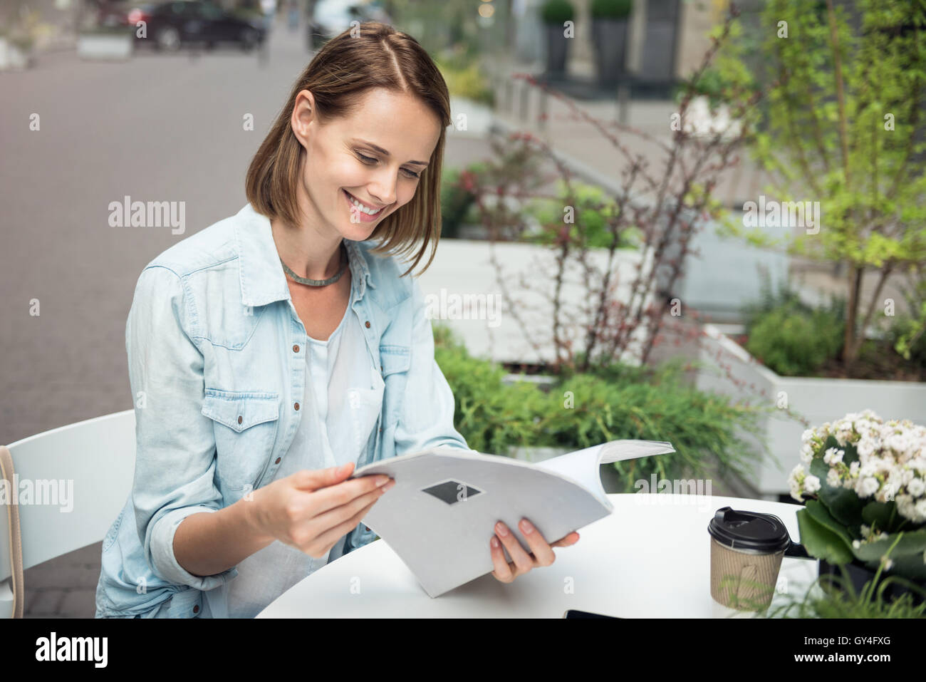Woman reading magazine outside hi-res stock photography and images - Alamy