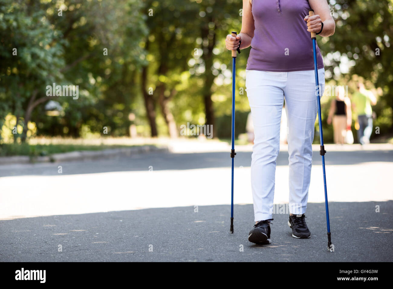 Old woman walking stick park hi-res stock photography and images - Alamy