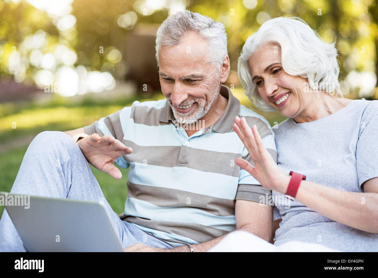 Elderly family using internet for communication sitting in a park Stock ...