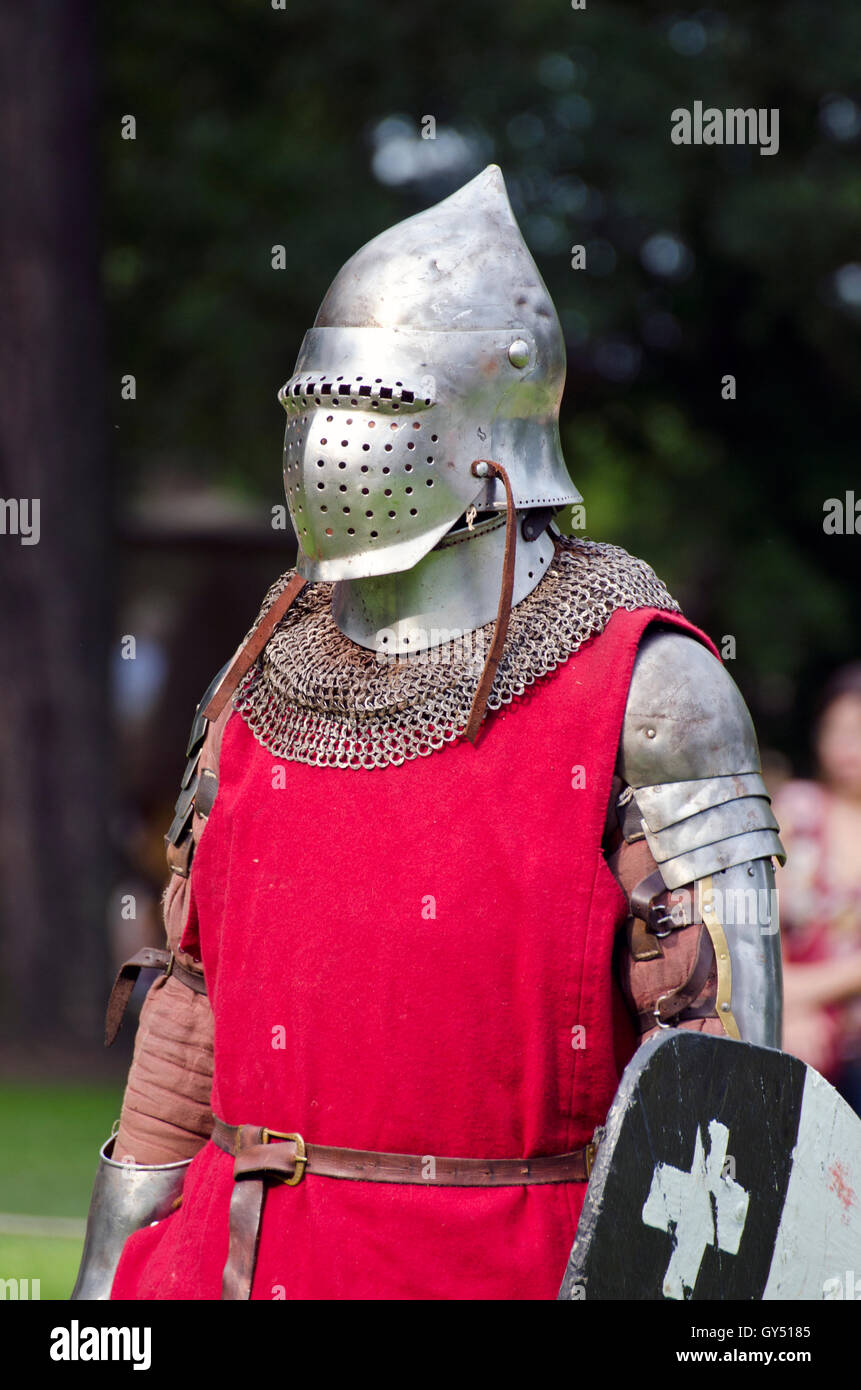 Knight actor with red clothes and armor and shield in medieval festival ...