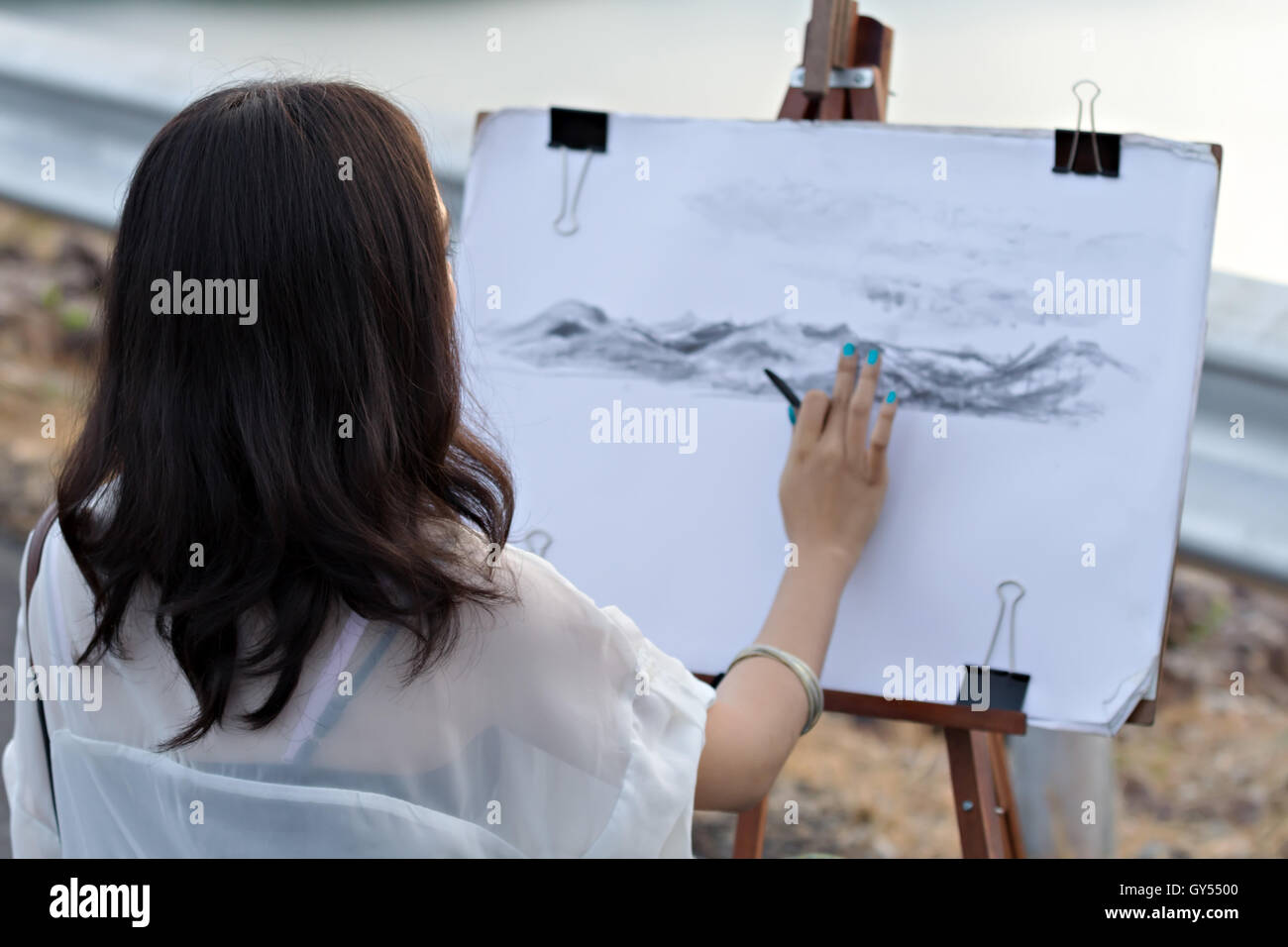 Young artist sketching a landscape focus on head Stock Photo - Alamy
