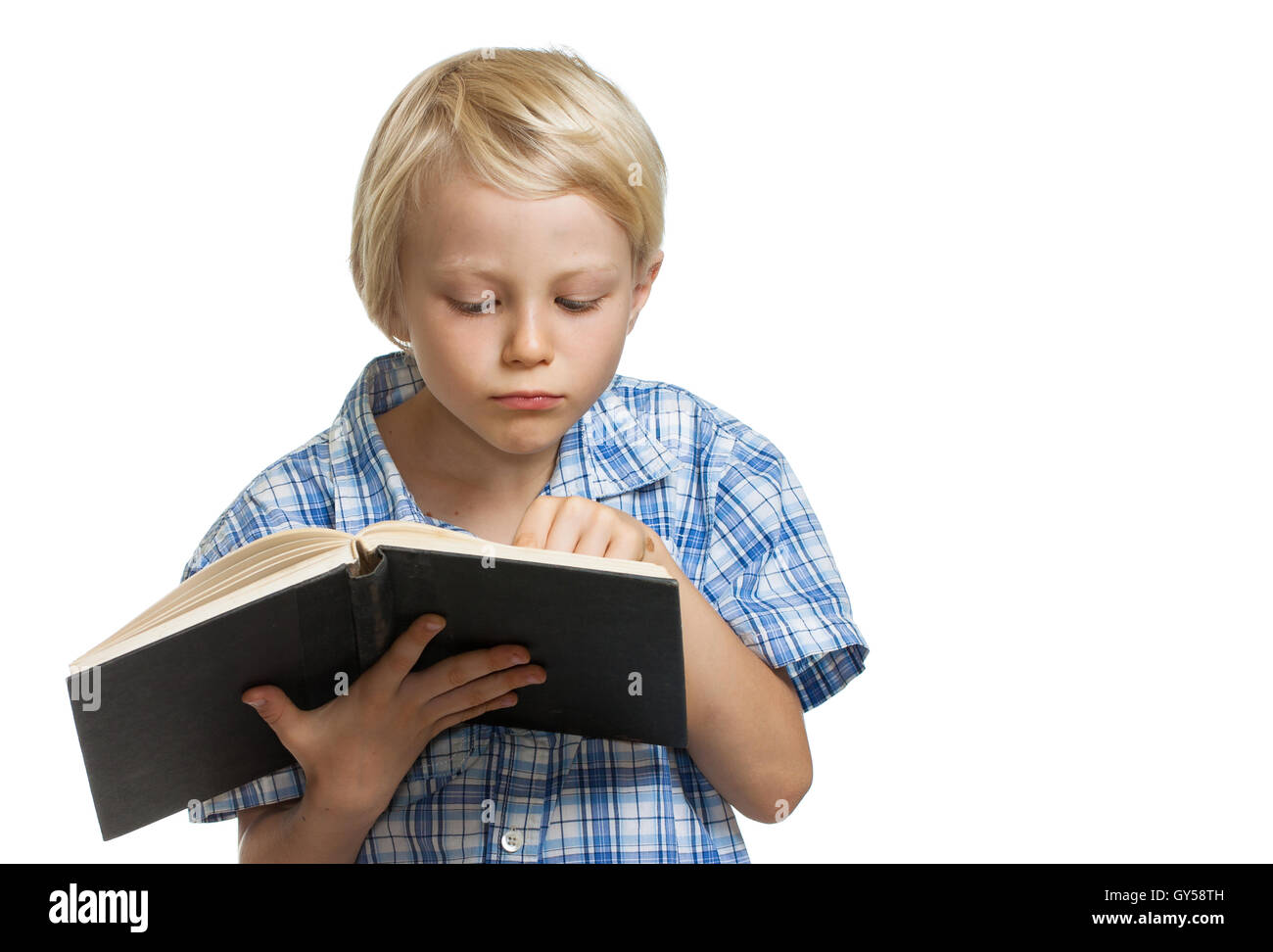 Young boy reading a thick book Stock Photo - Alamy