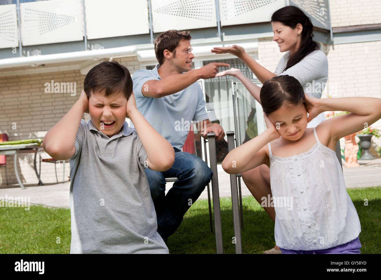 Children suffers while parents fight in background Stock Photo - Alamy