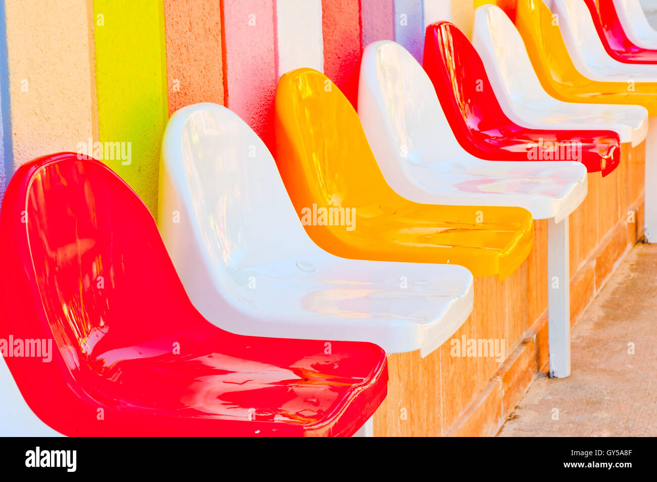 a number of multi-colored seats for children Stock Photo - Alamy