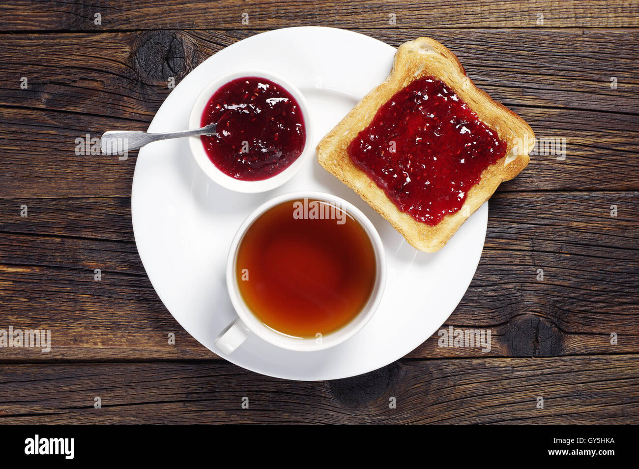 Toast with jam and cup of tea on dark wooden table. Top view Stock ...