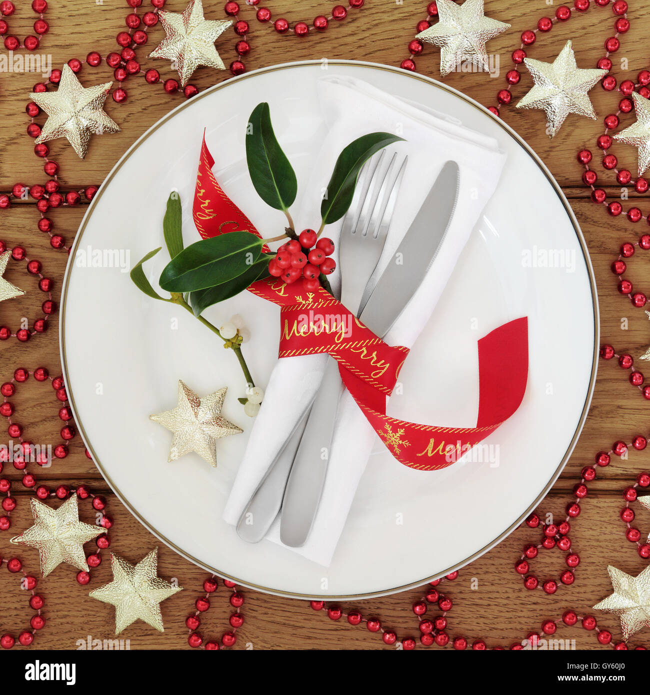 Christmas dinner table setting with white porcelain plate, cutlery, red ...