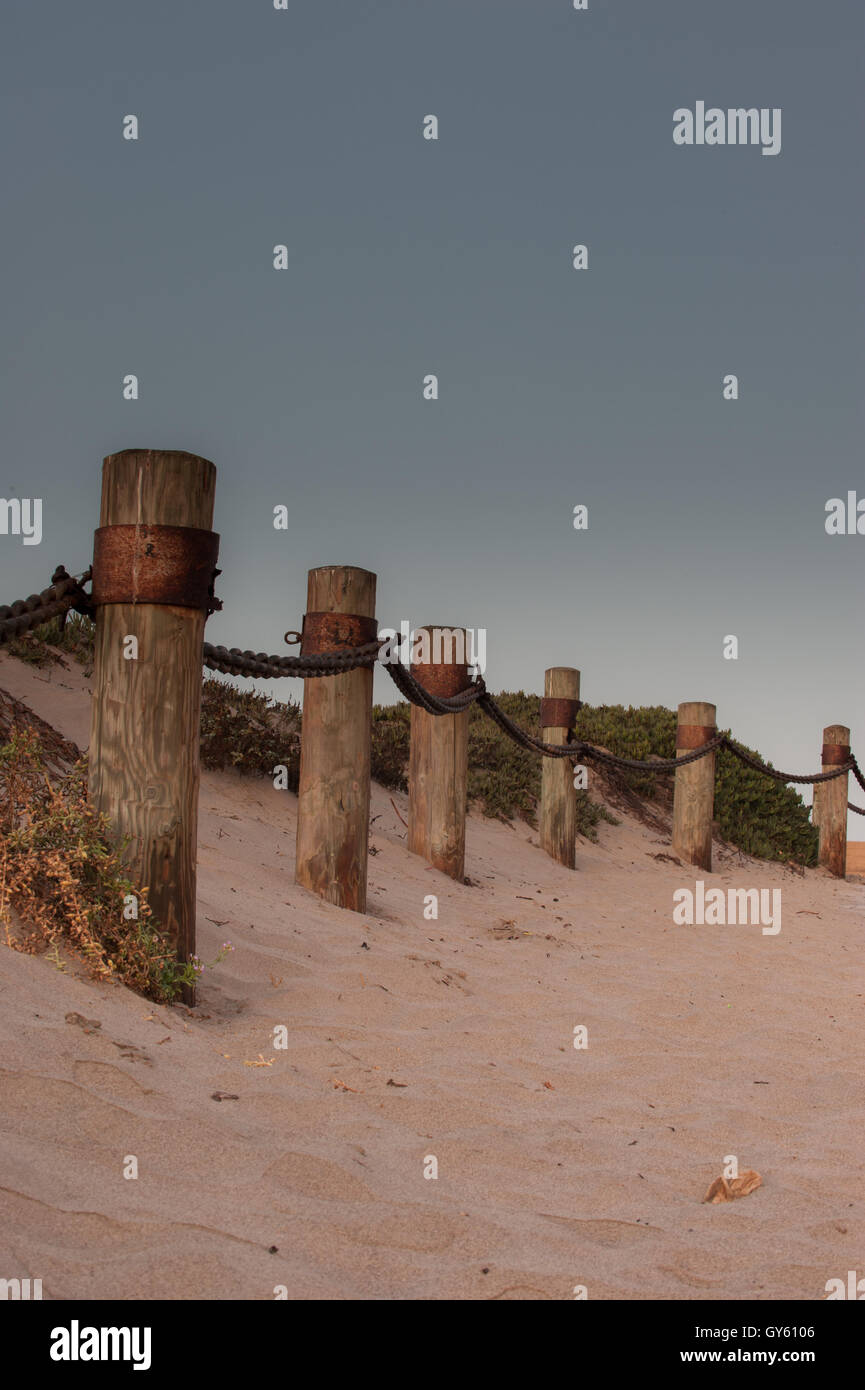 Wooden pilings connected by iron chain at beach Stock Photo - Alamy