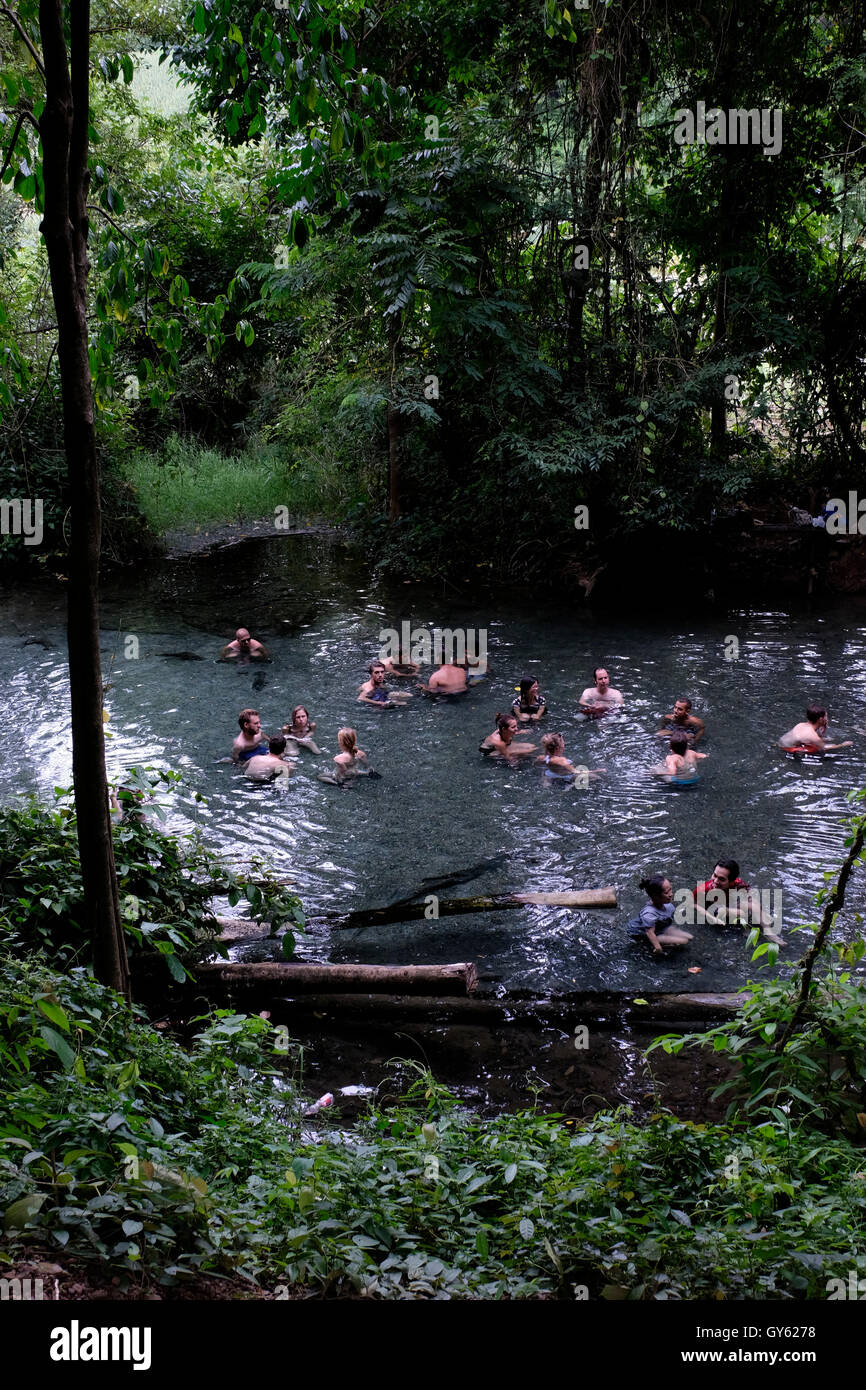 Tourists bathing in the shallow lagoon of Sai Ngam Hot Springs ...