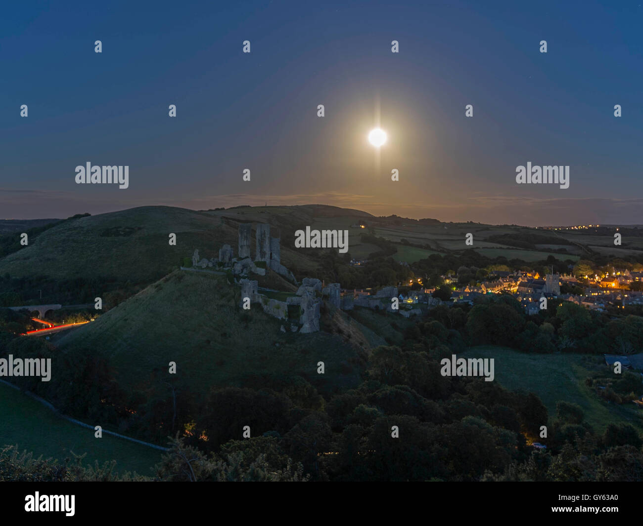 Landscape depicting late summer Harvest Moon rise at Corfe Castle ...
