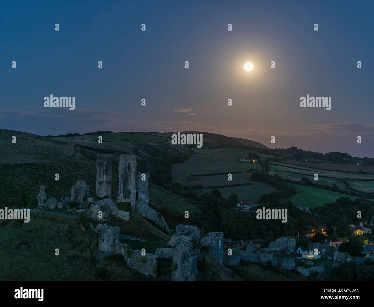 Landscape depicting late summer Harvest Full Moon rise at Corfe Castle ...