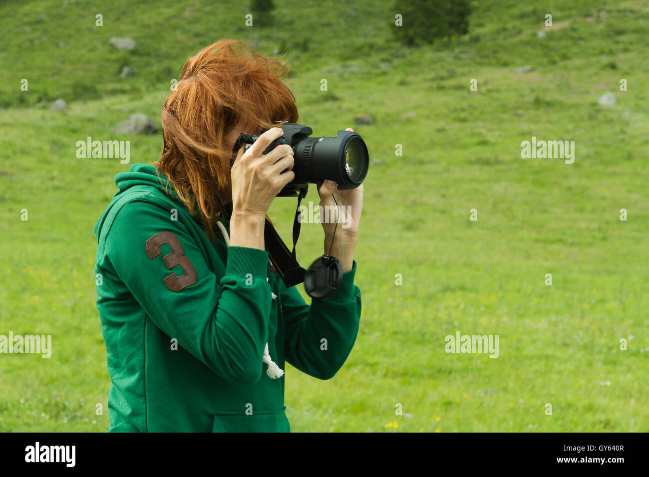 Portrait of nature photographer woman taking landscape pictures in the ...